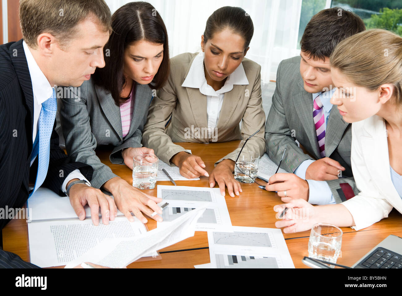 Image of five people looking at business-plan and brainstorming Stock ...