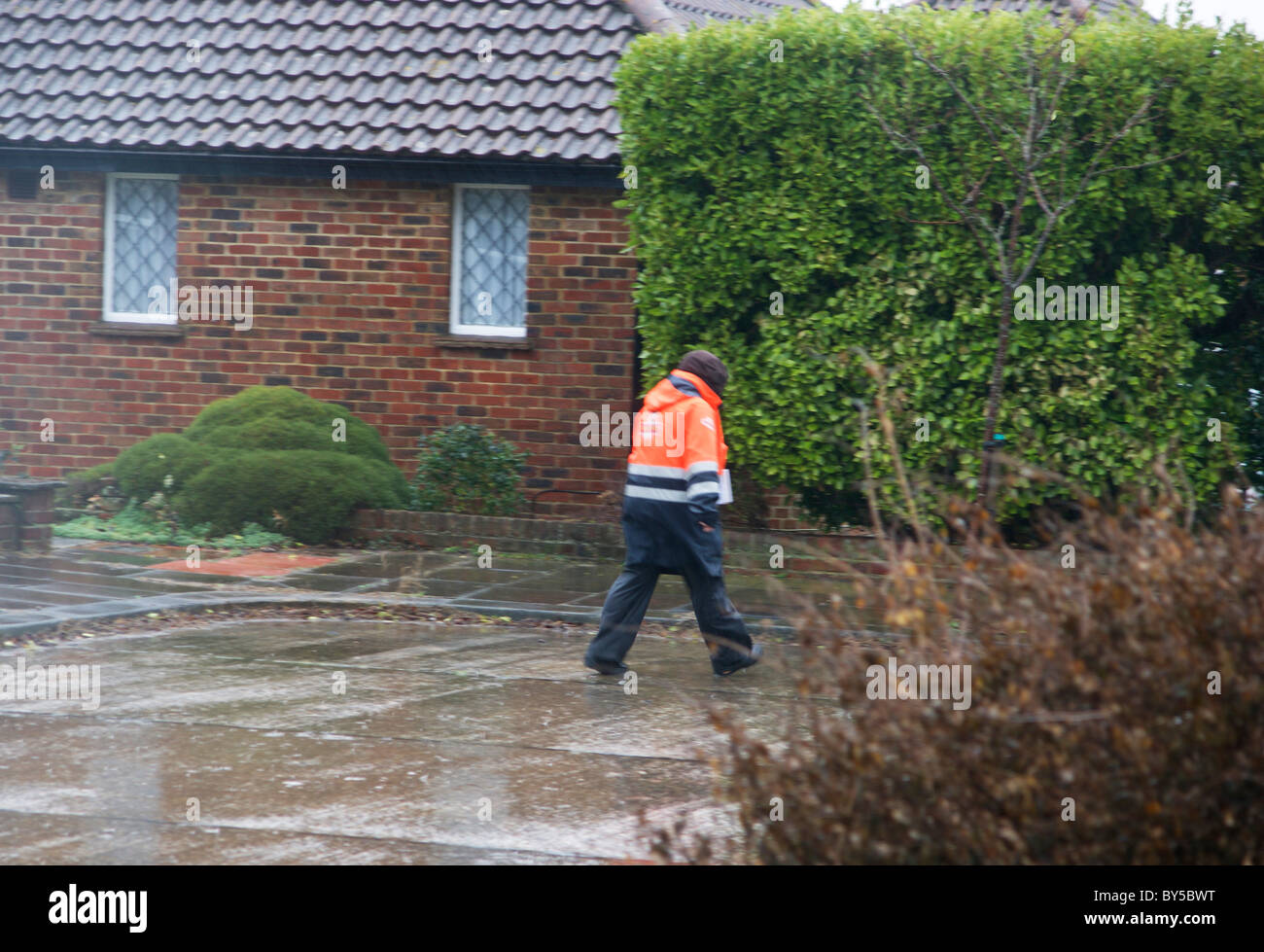 postman on round delivering the post in extreme weather conditions of ...