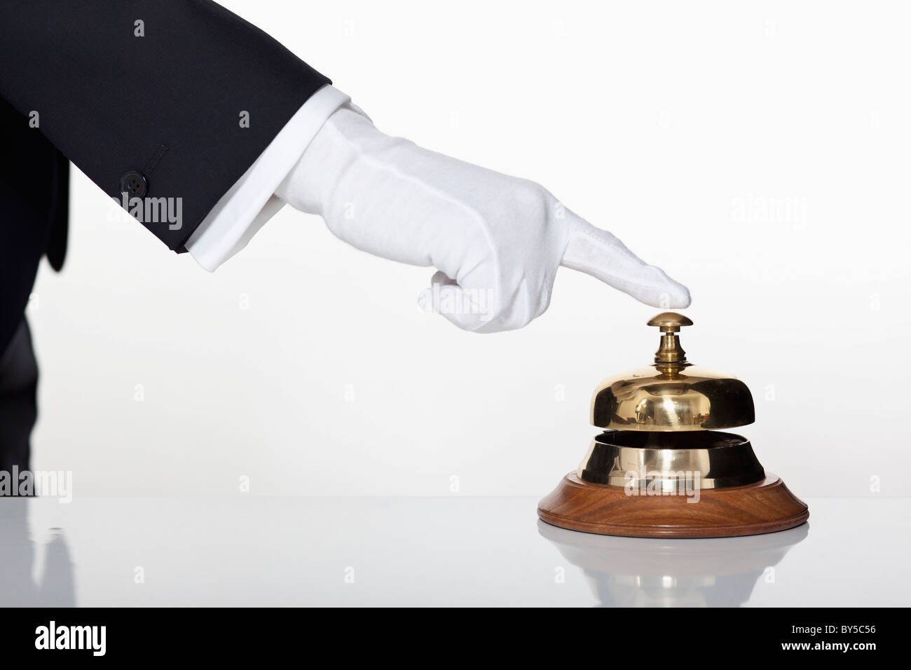 A butler pressing a service bell, focus on hand Stock Photo - Alamy