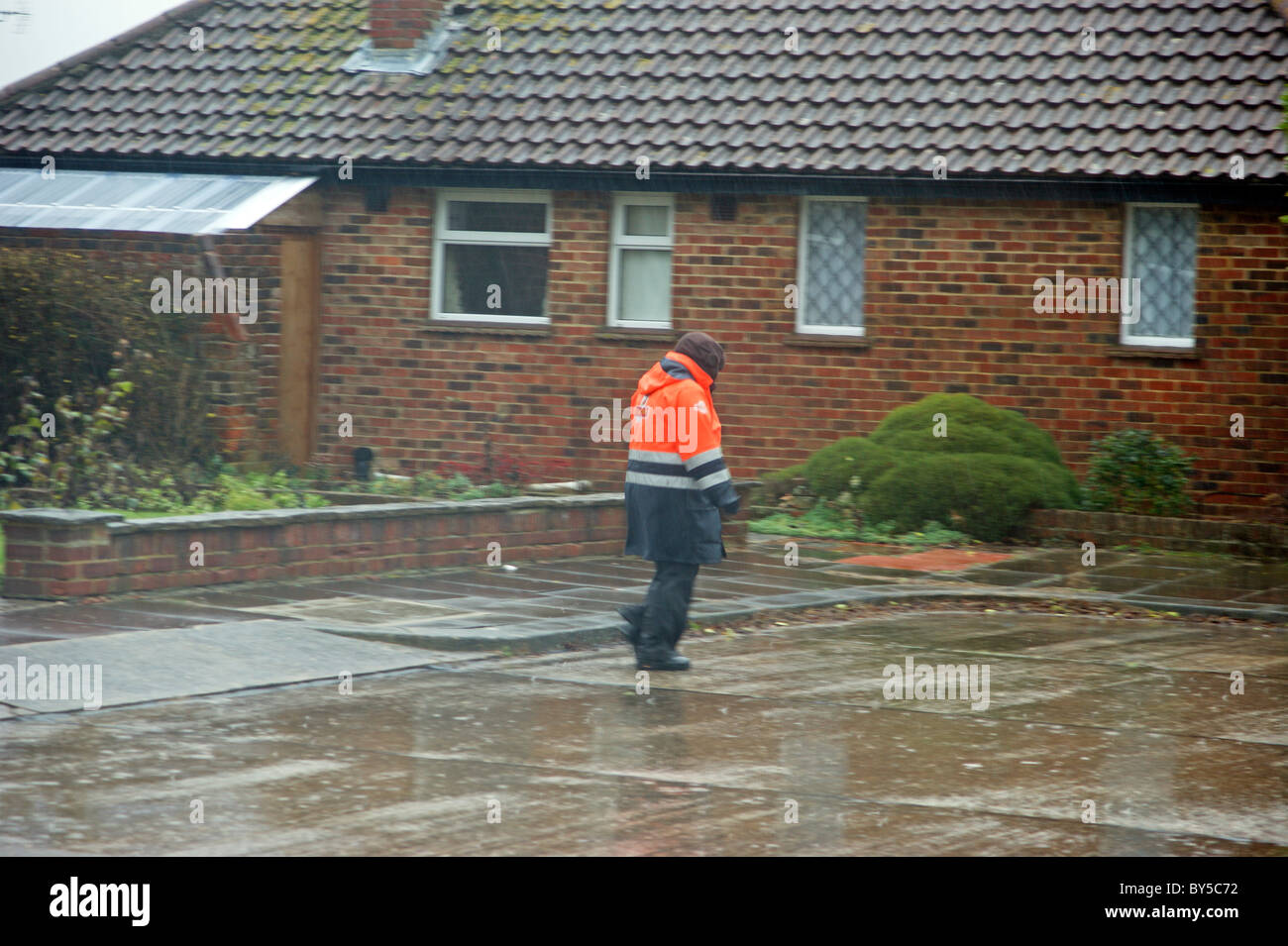 postman on round delivering the post in extreme weather conditions of ...