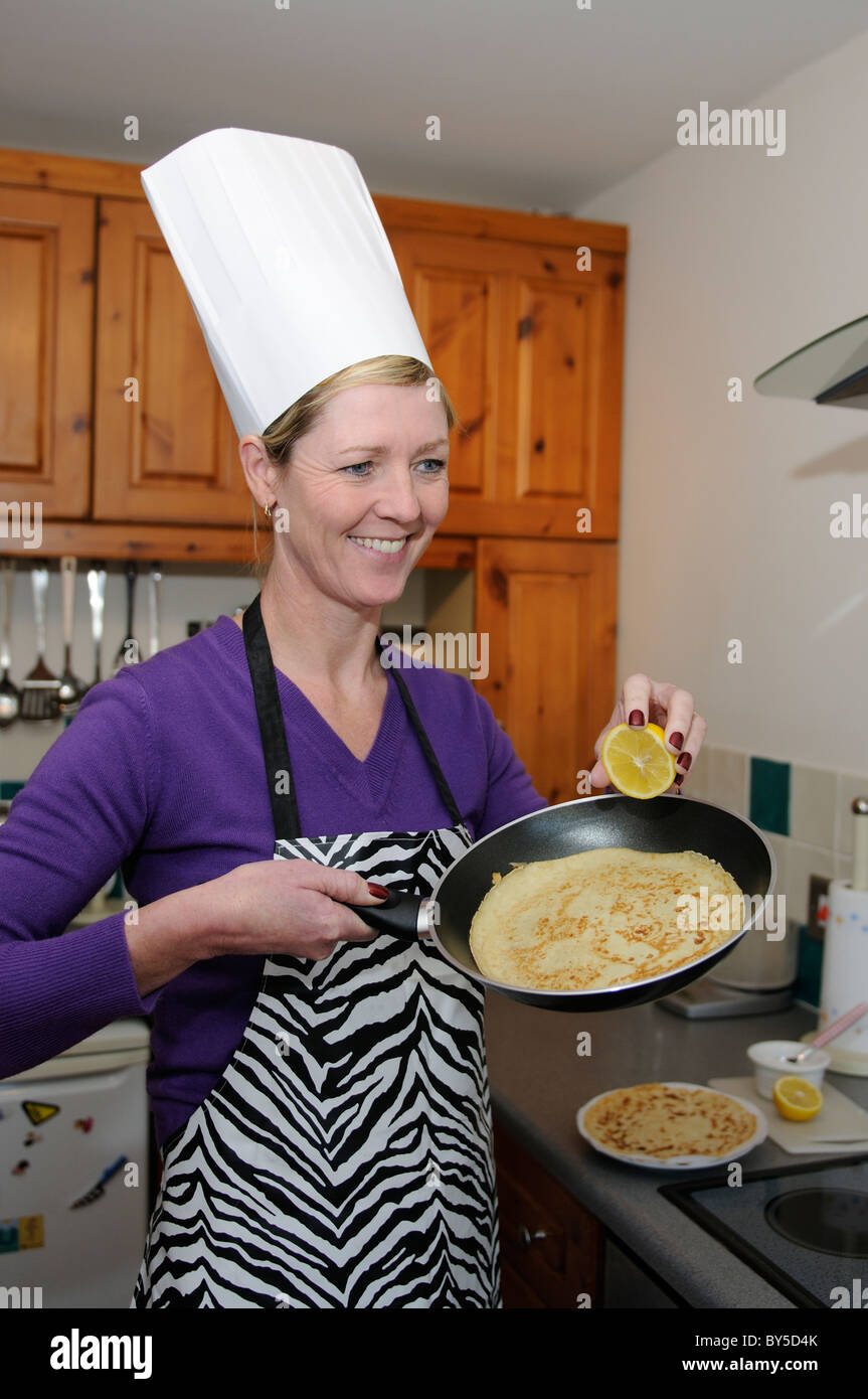 Pancake Day Woman working in her kitchen cooking pancakes with a ...