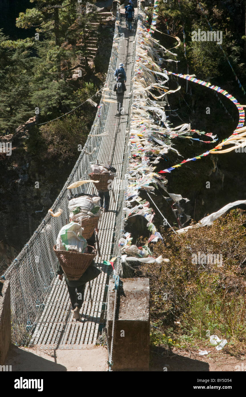 prayer flags blowing on suspension bridge crossing in the Everest ...