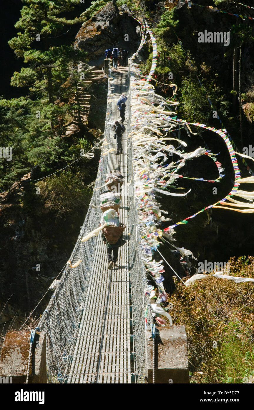 prayer flags blowing on suspension bridge crossing in the Everest ...
