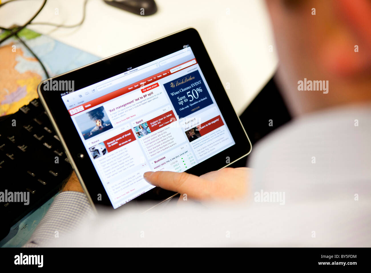 man using apple ipad at his desk in office Stock Photo - Alamy