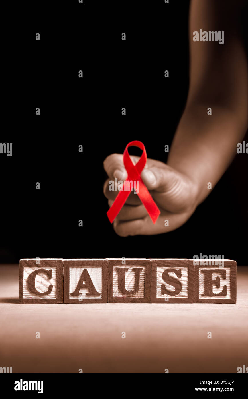 Word 'Cause' from wooden block with hand holding red ribbon on dark ...