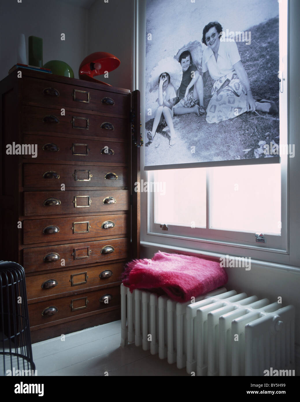 Black+white photograph-patterned blind on window above large radiator ...