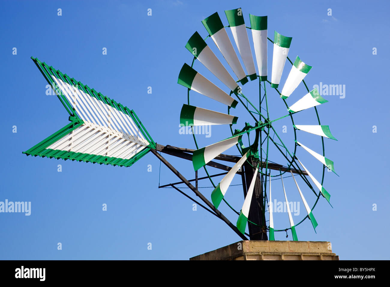 Isolated white and green windmill in Majorca with a blue sky as ...
