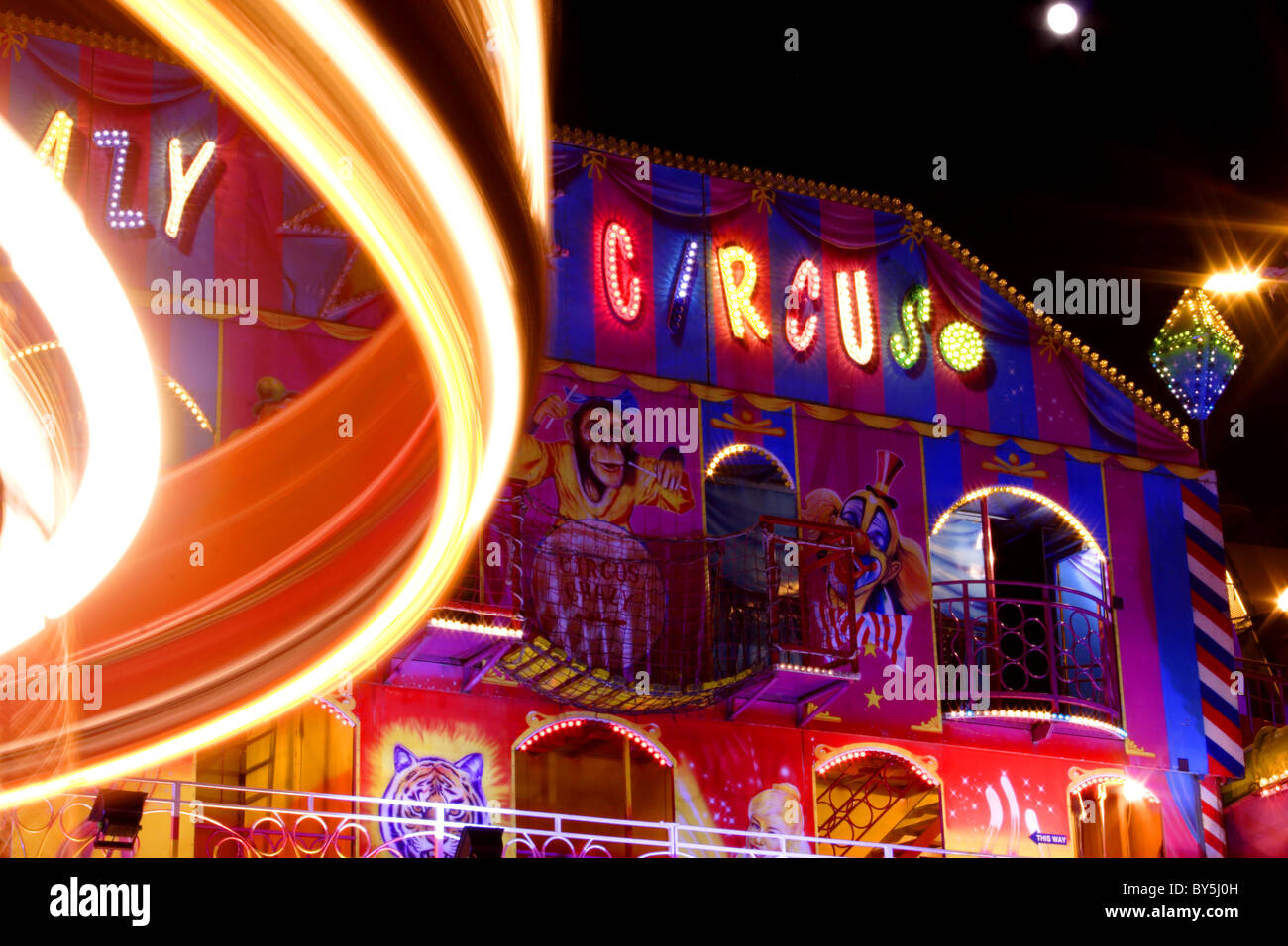 Blurred lights from ride, and mobile circus, night time, German market ...