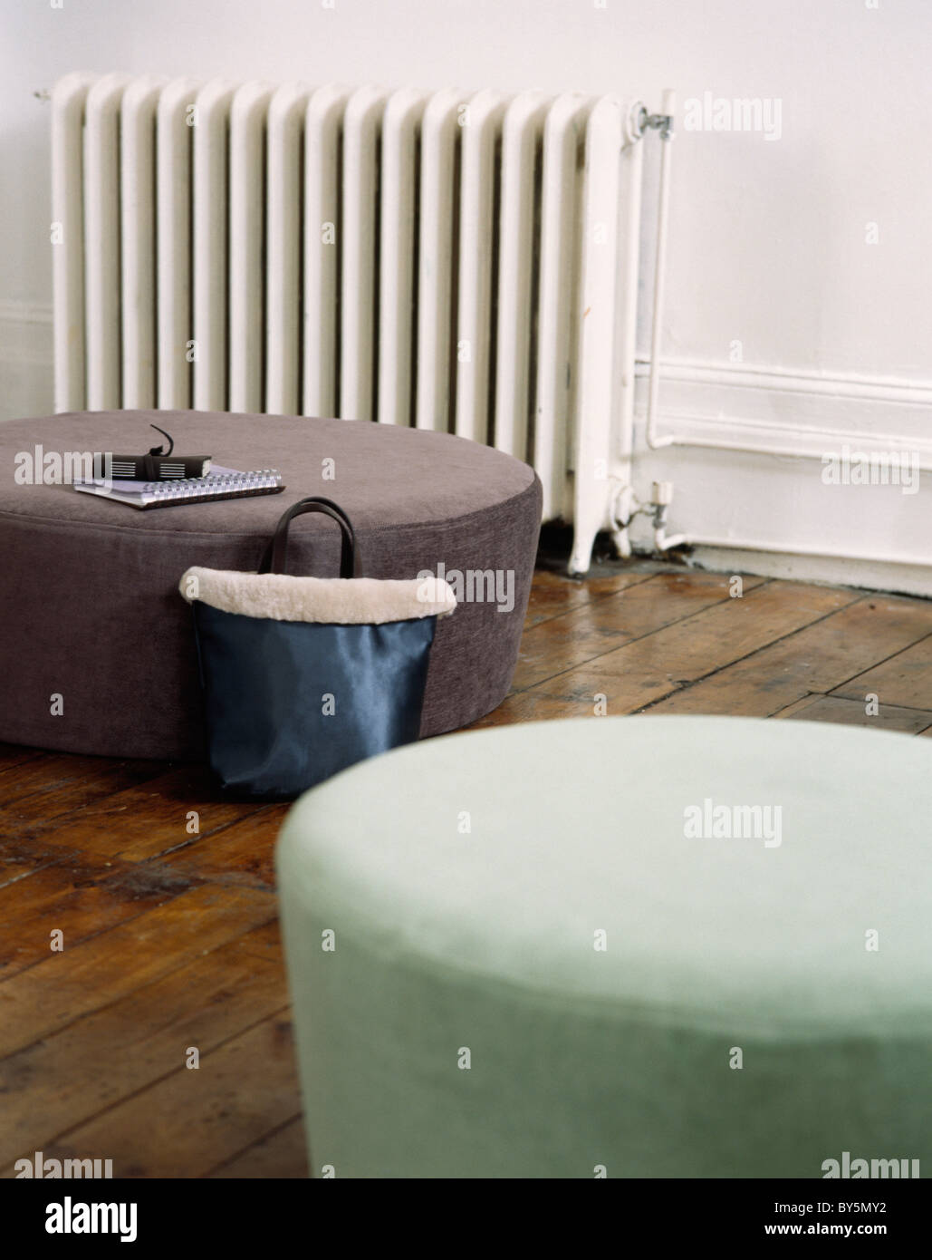 Large pale green and brown circular stools in living room with white ...