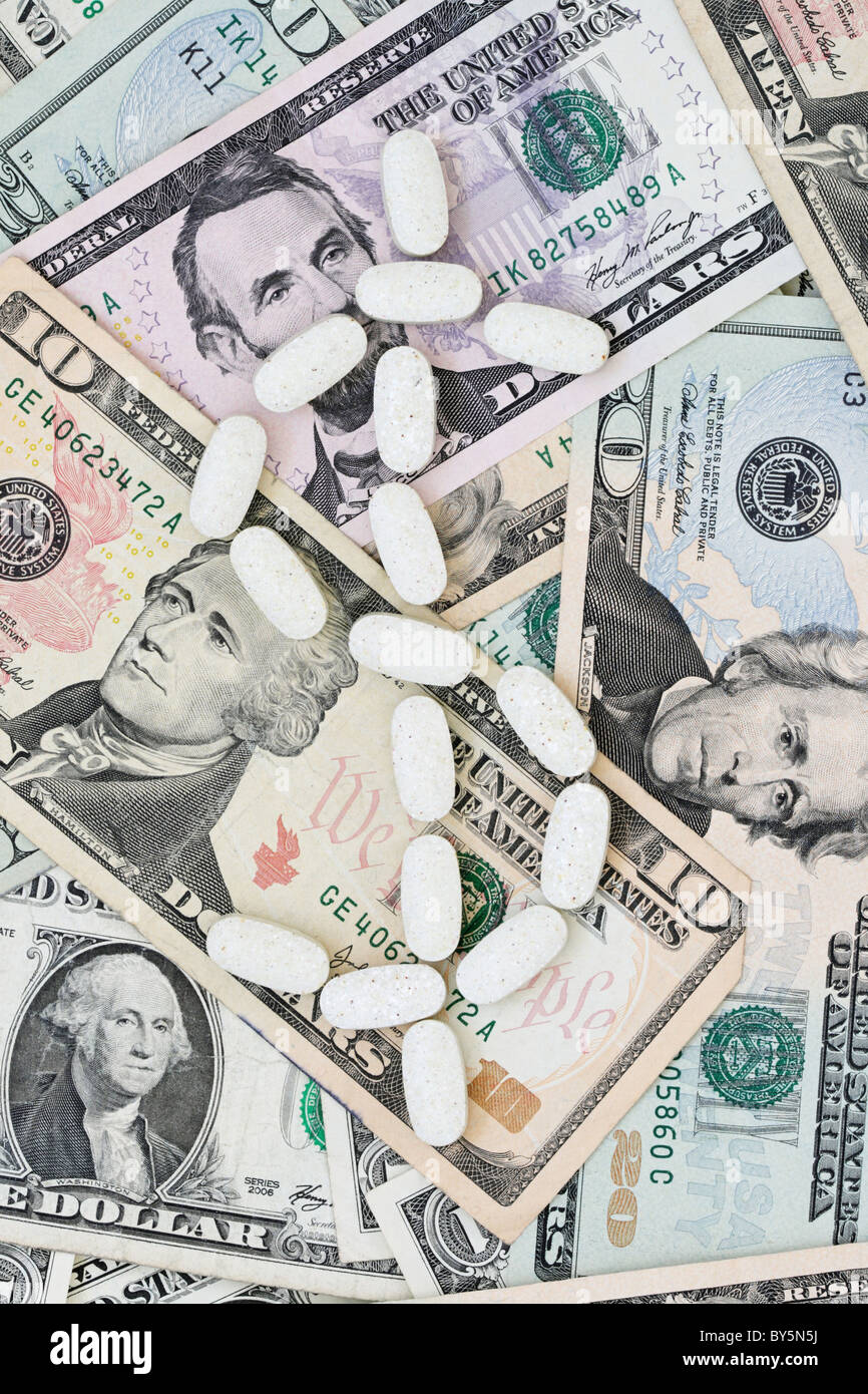 dollar sign made of tablet pills on a background of US paper money ...