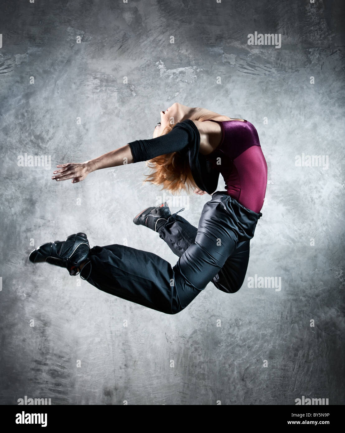 Young woman dancer jumping. On wall background Stock Photo - Alamy