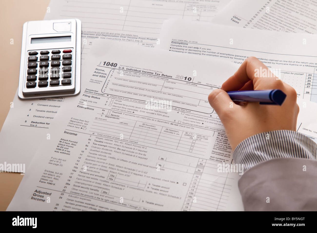 Woman hand filling income tax forms with calculator Stock Photo - Alamy