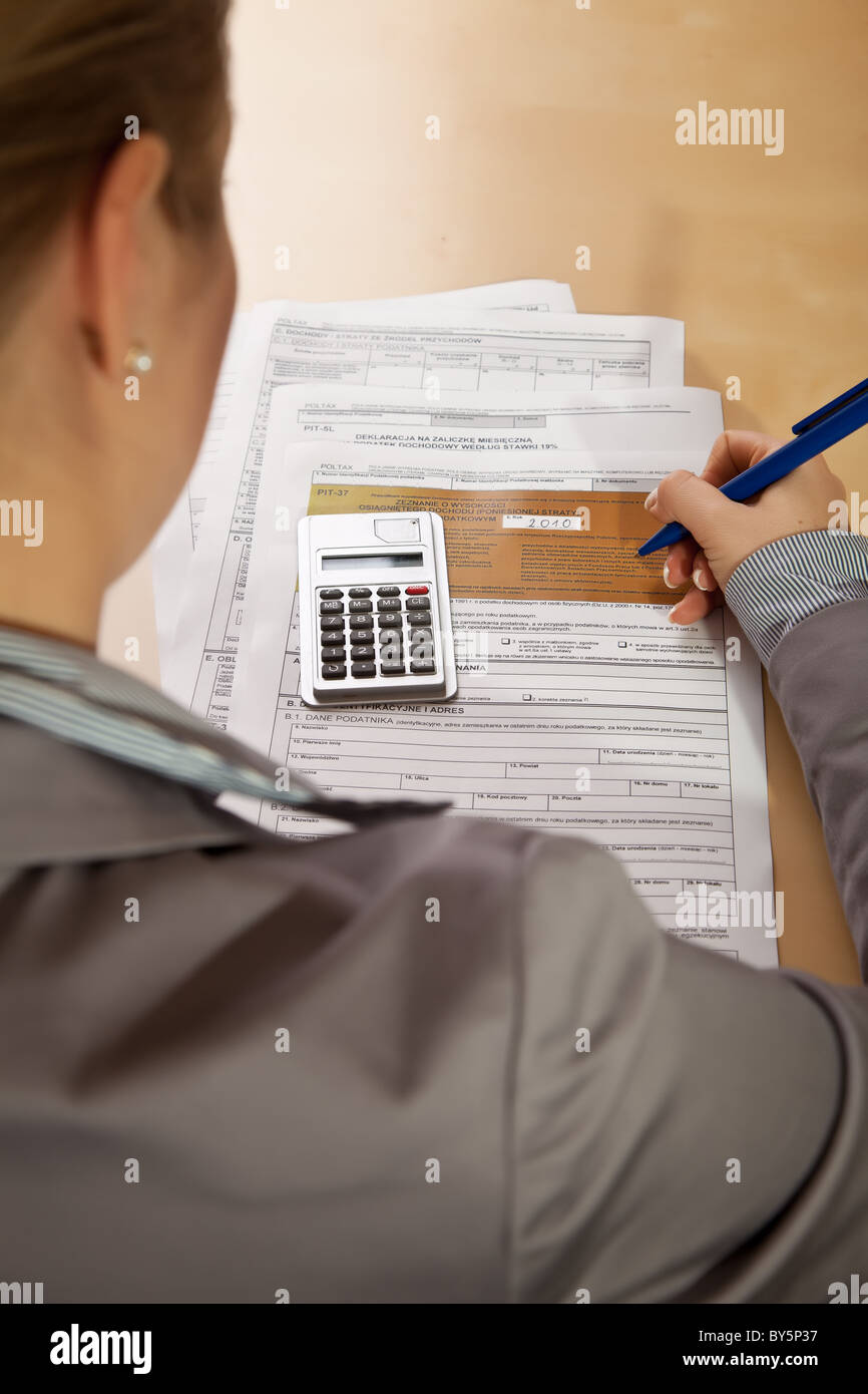 Woman hand filling income tax forms with calculator Stock Photo - Alamy