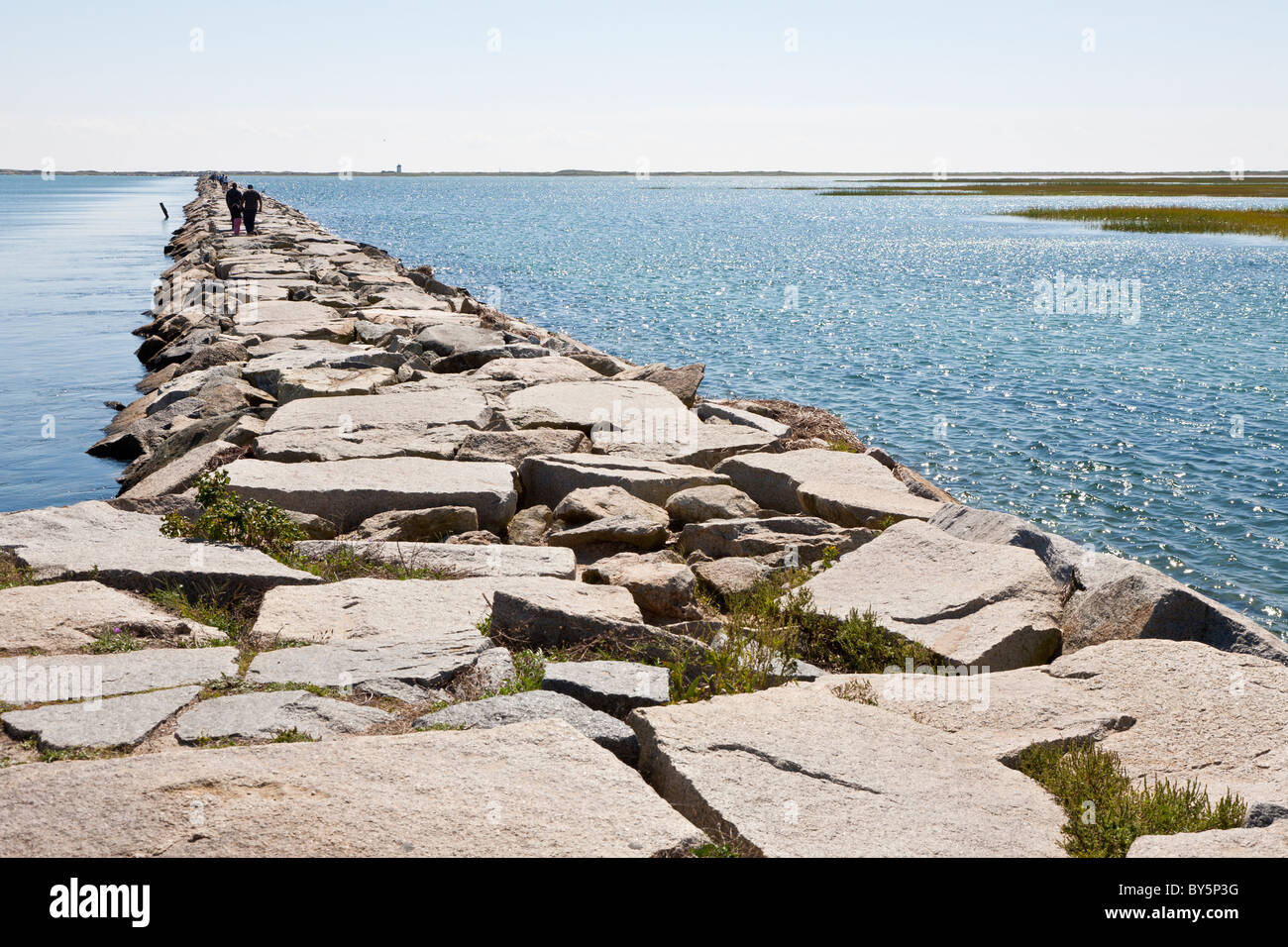 Visitors walk across west end of Provincetown Harbor on stone walkway ...