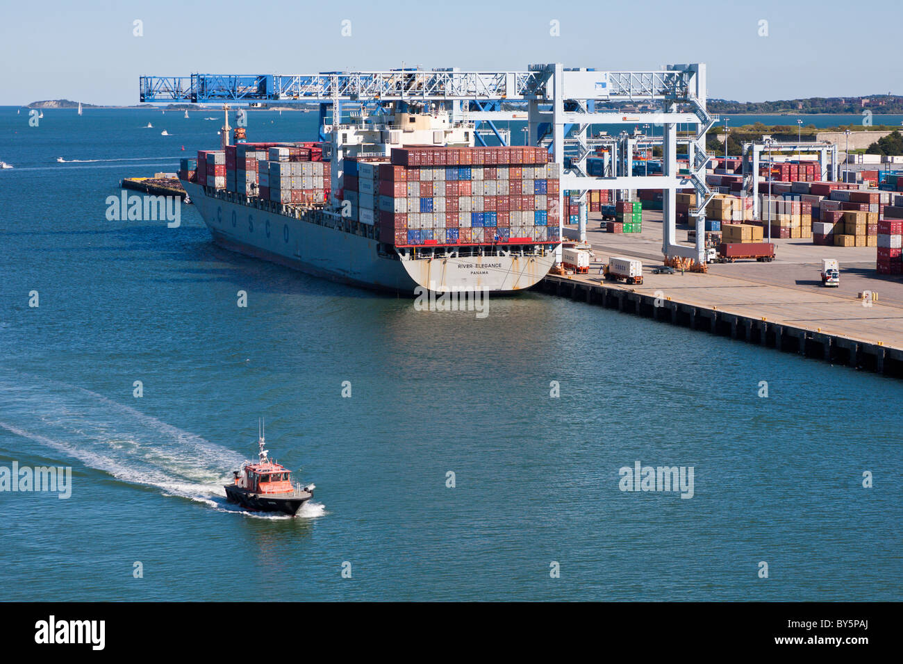 Pilot boat passing a container ship being loaded in Boston Harbor ...