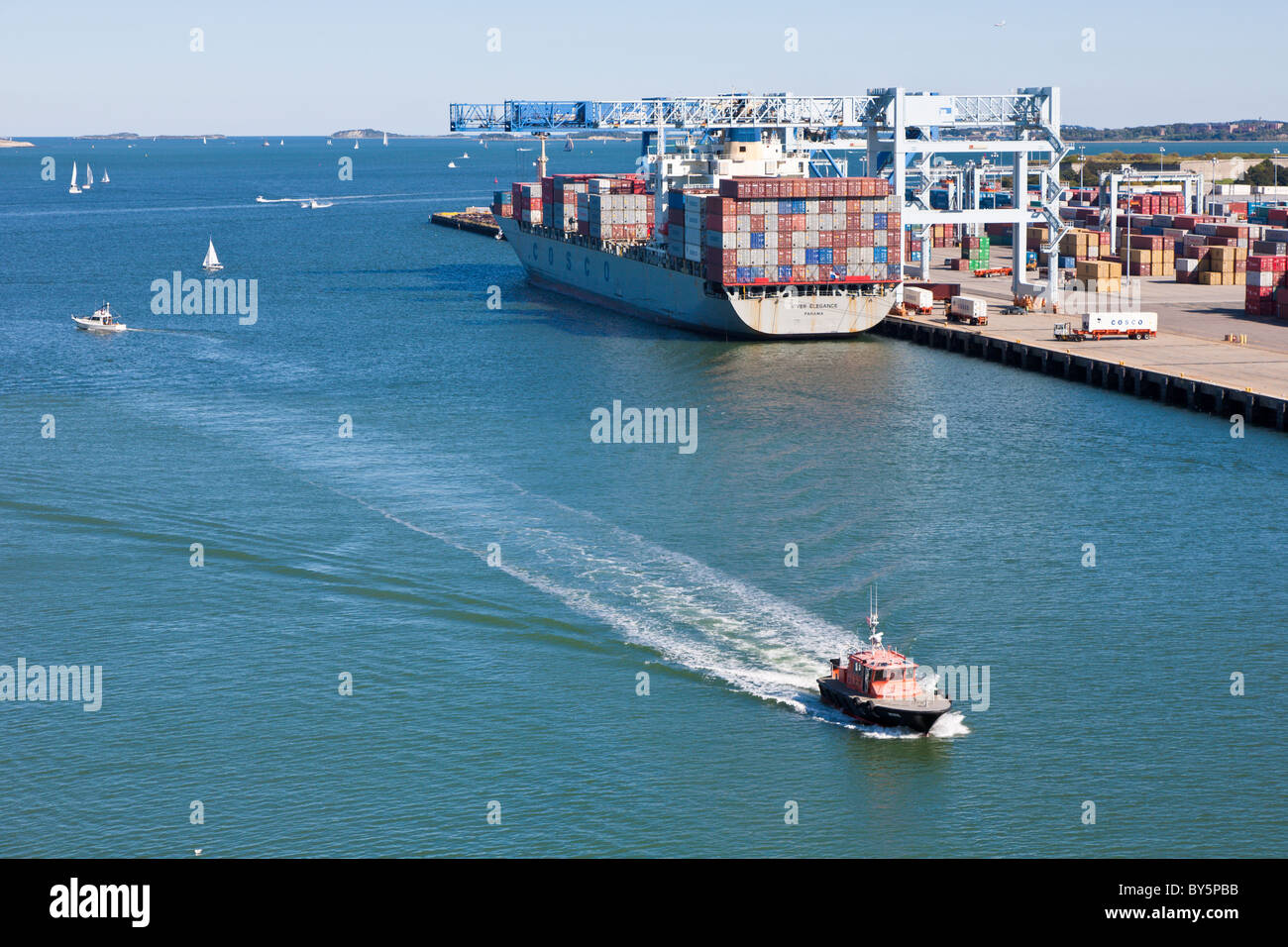 Pilot boat passing a container ship being loaded in Boston Harbor ...