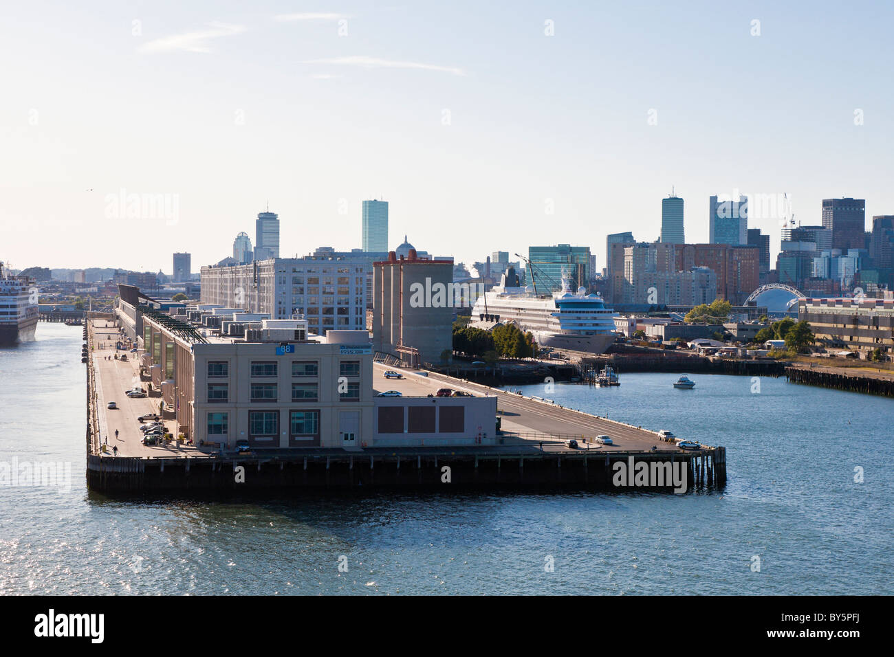 City of Boston, Massachusetts looms behind warehouses at docks of ...