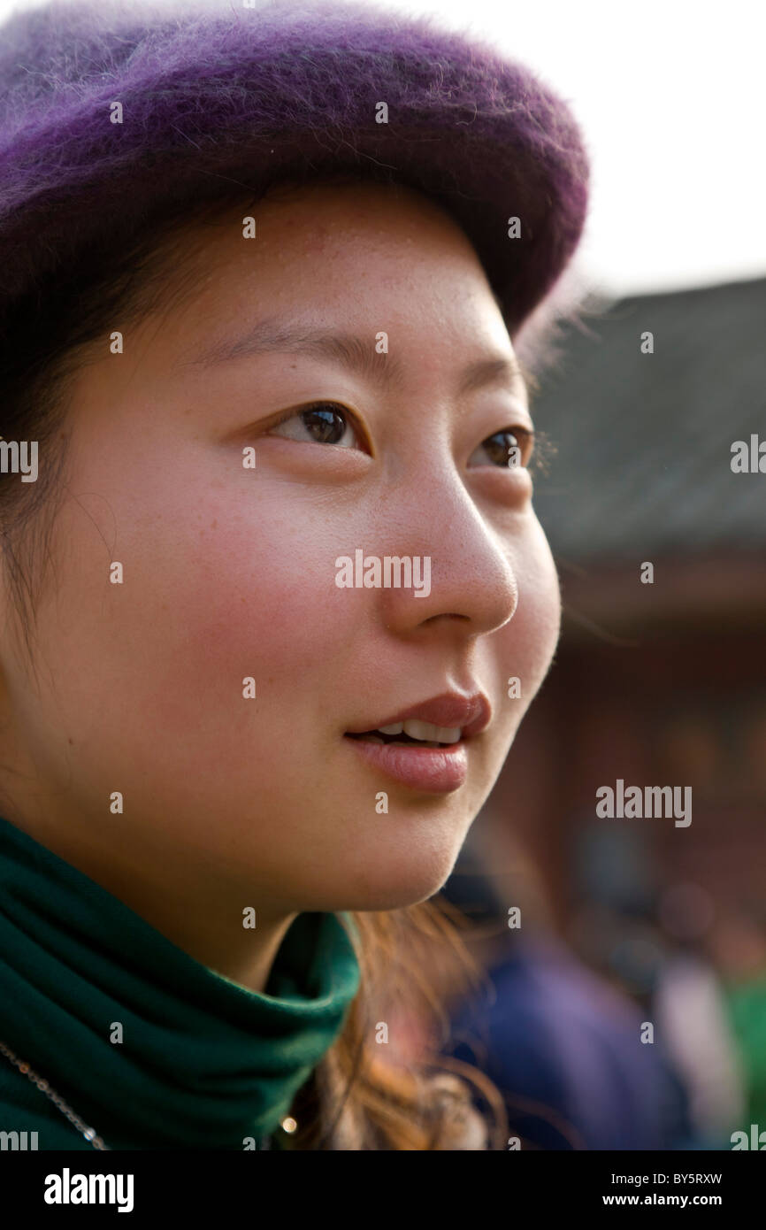 Beautiful young Chinese girl in green top and purple cap in Huanglongxi ...