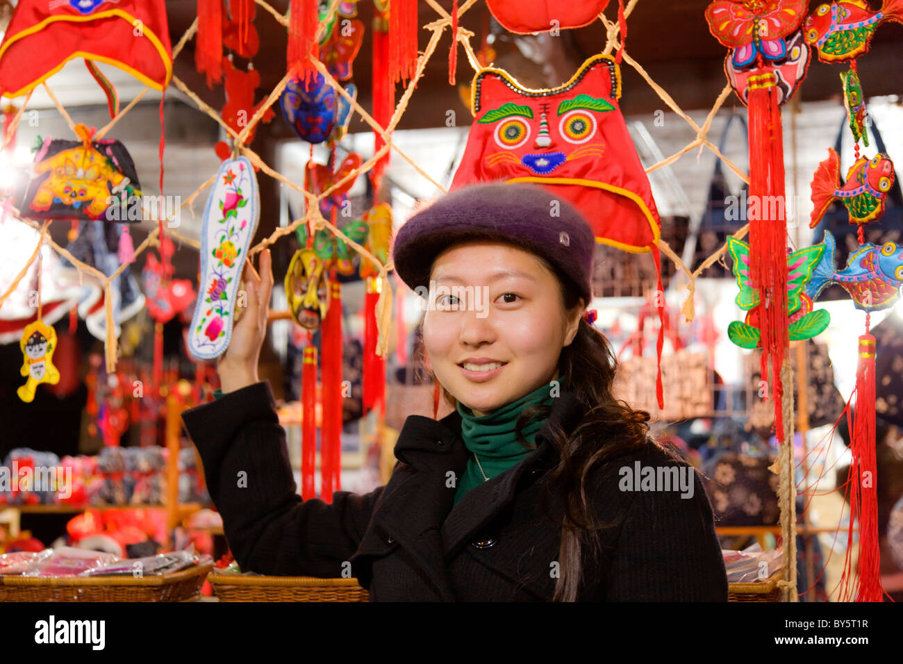 Beautiful young Chinese girl wearing purple fluffy cap shopping in ...