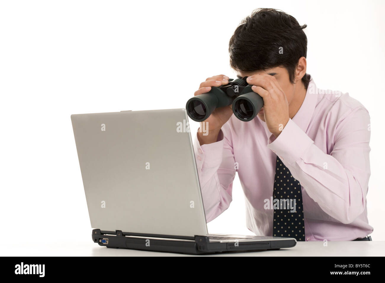 Horizontal image of professional looking at laptop through binoculars ...
