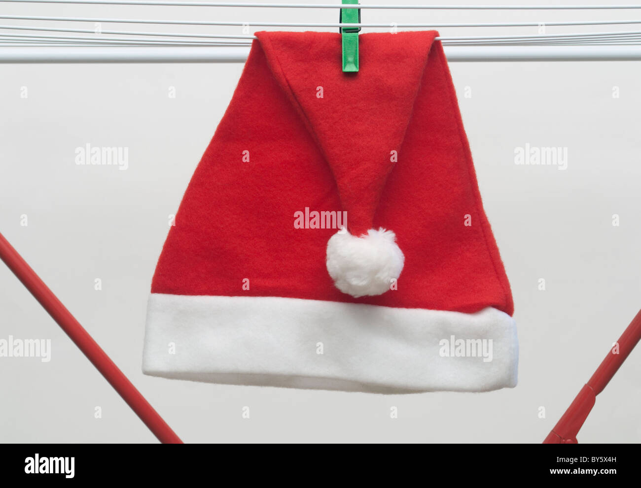 Santa Claus hat hanging on a clothesline Stock Photo - Alamy