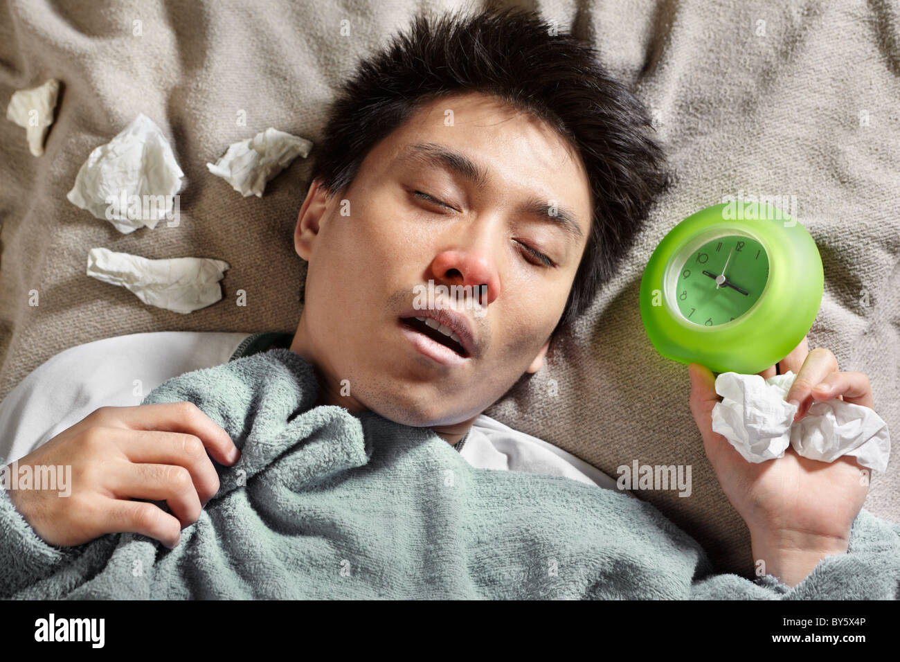 A sick male sleeping with clock near him Stock Photo - Alamy