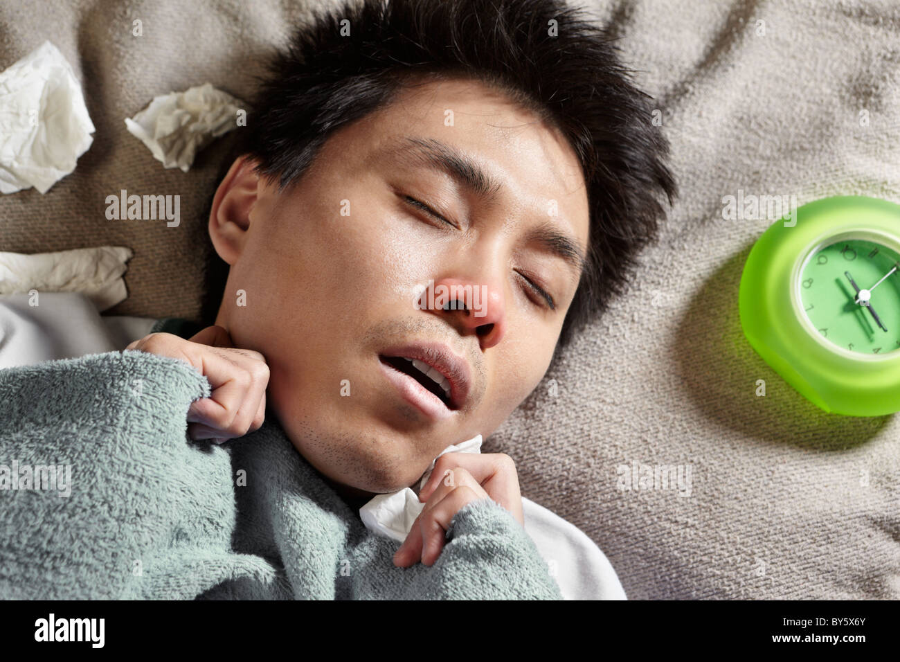 A sick male sleeping with clock near him Stock Photo - Alamy