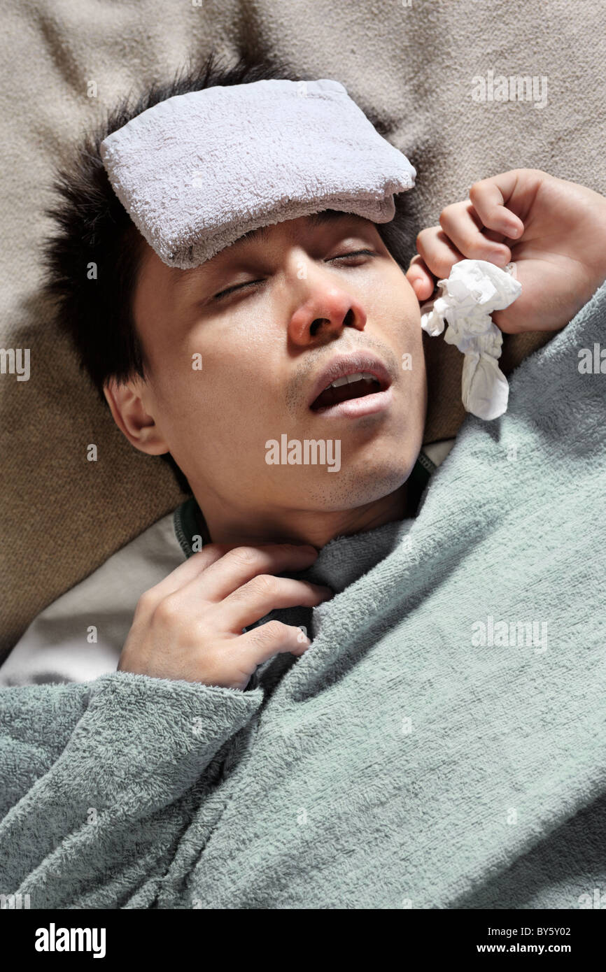 A Sick Male Sleeping With Wet Towel On His Forehead To Reduce High High