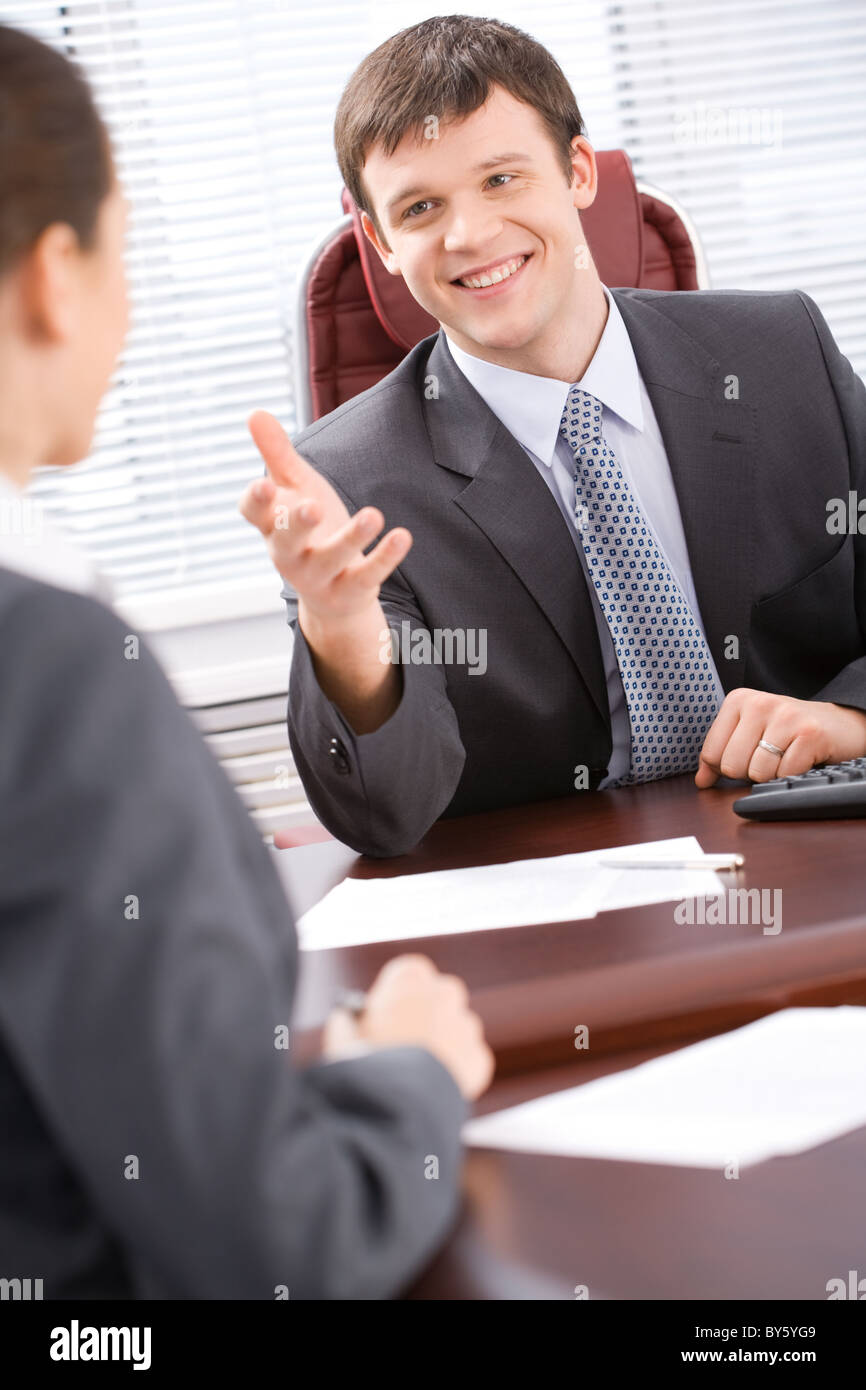 Portrait of boss sitting at the table and telling his business idea to ...