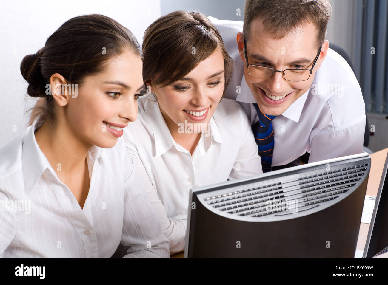 Team of business people looking at monitor of computer Stock Photo - Alamy