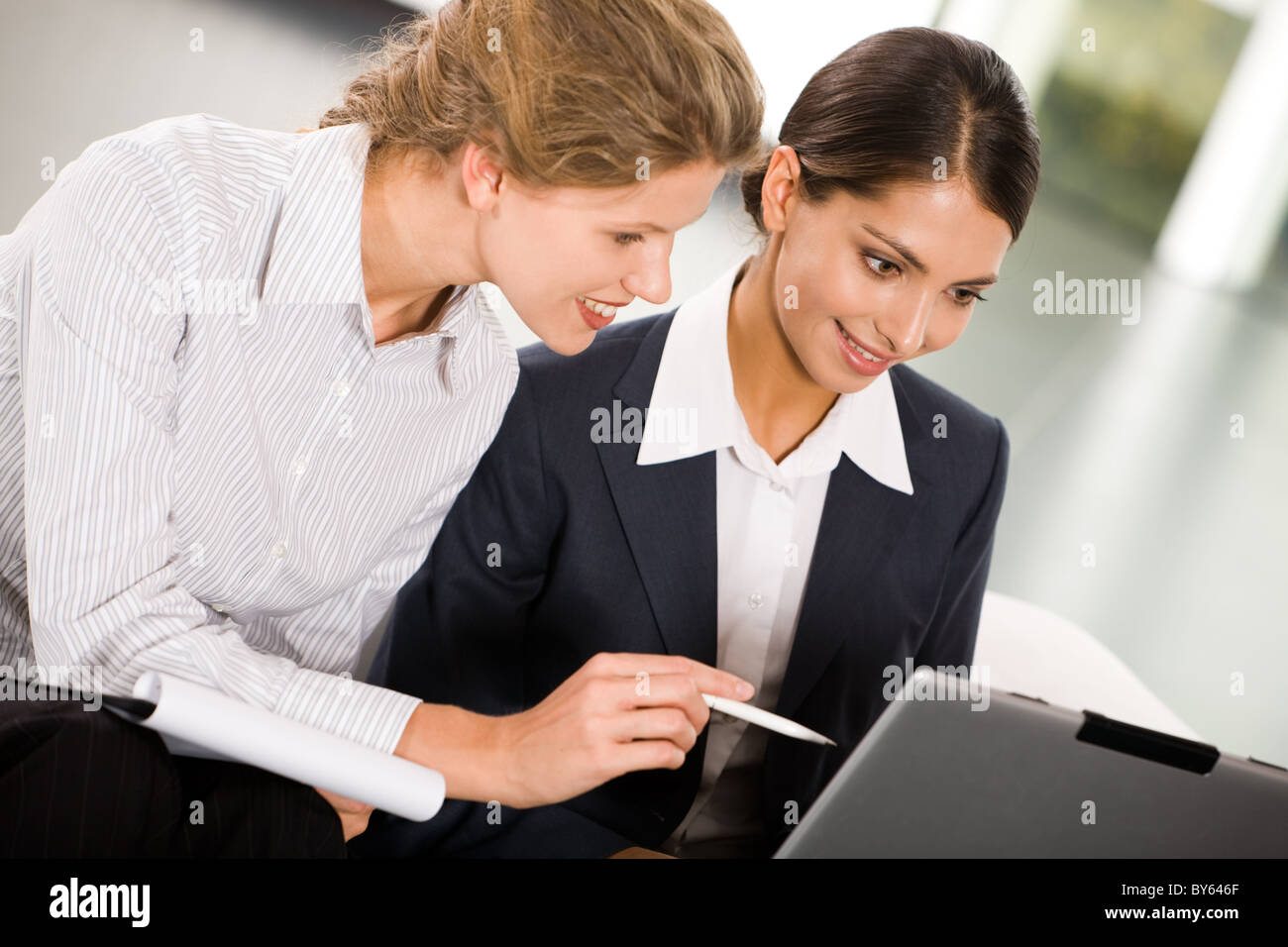 Portrait of two smiling business women working together Stock Photo - Alamy