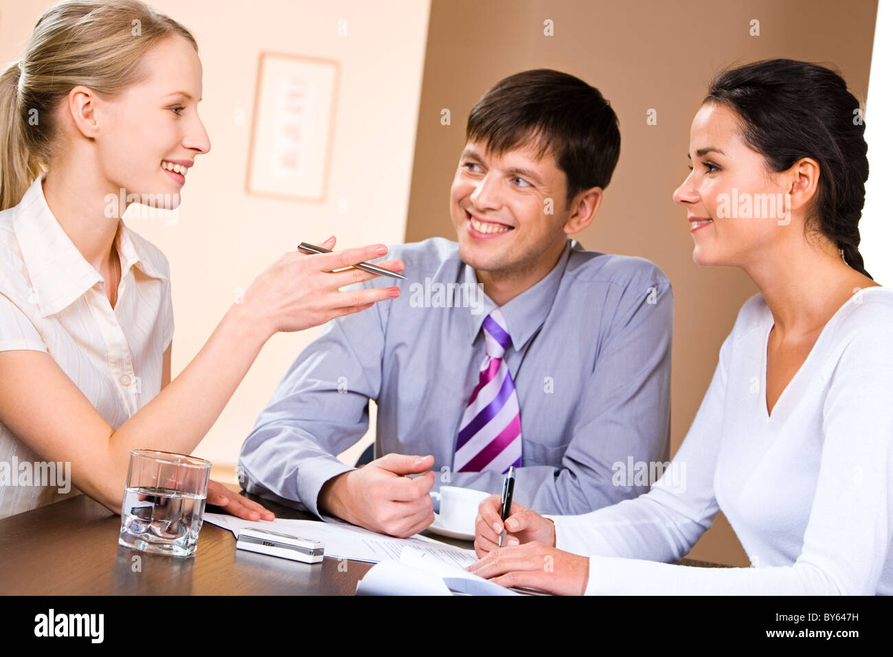 Businesspeople talking together around table hi-res stock photography ...