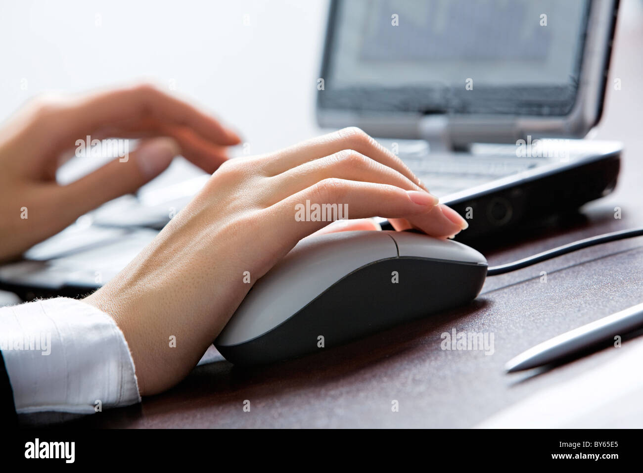 Human hands touching computer mouse and keys of opened laptop Stock ...