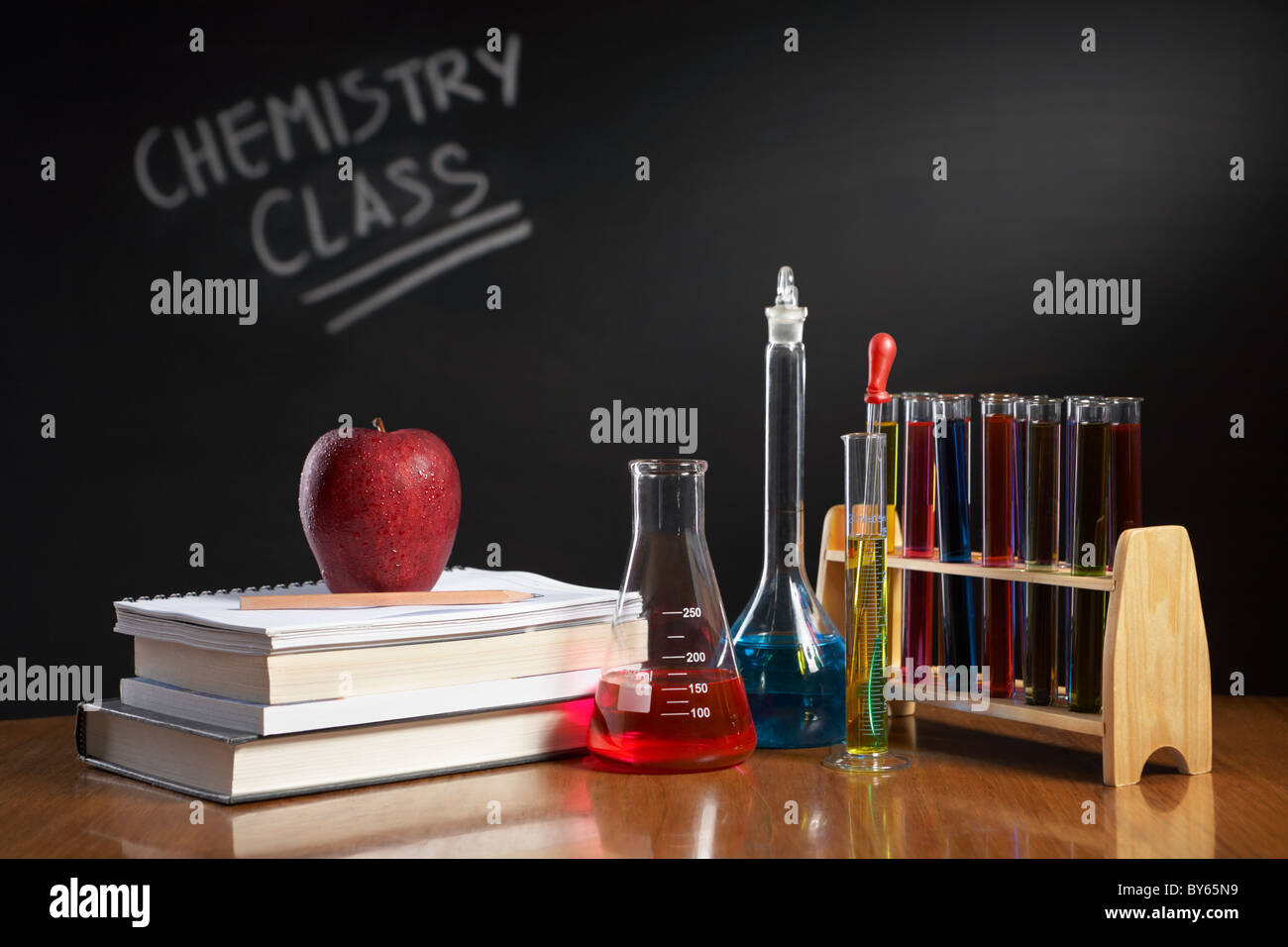 Chemistry class concept with red apple on pile of books and chemical ...