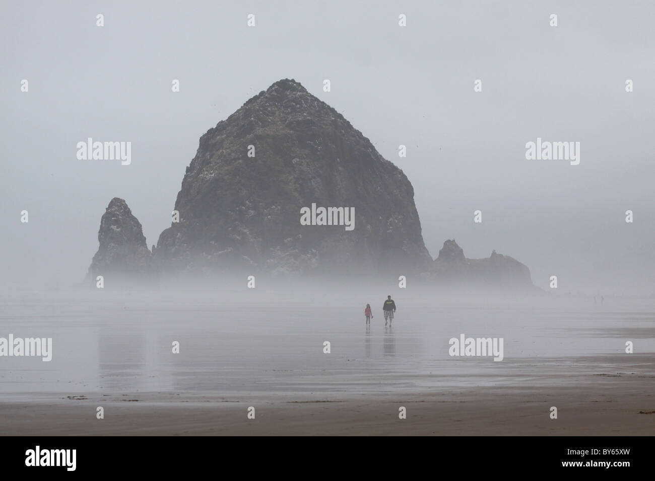 beach hikers Haystack Rock Cannon Beach Oregon Coast fog Stock Photo ...