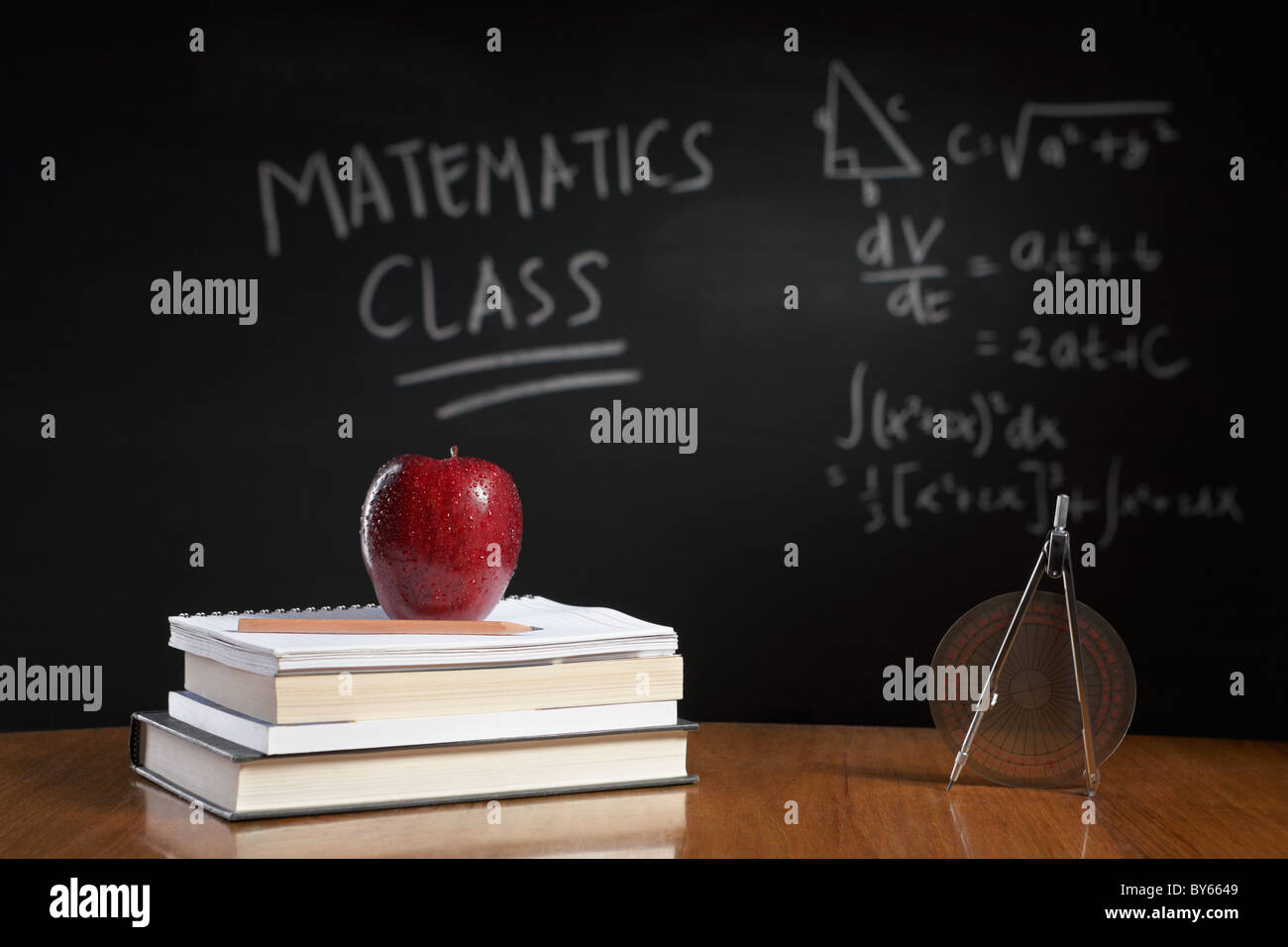 Mathematics class concept with red apple on pile of books and drawing ...