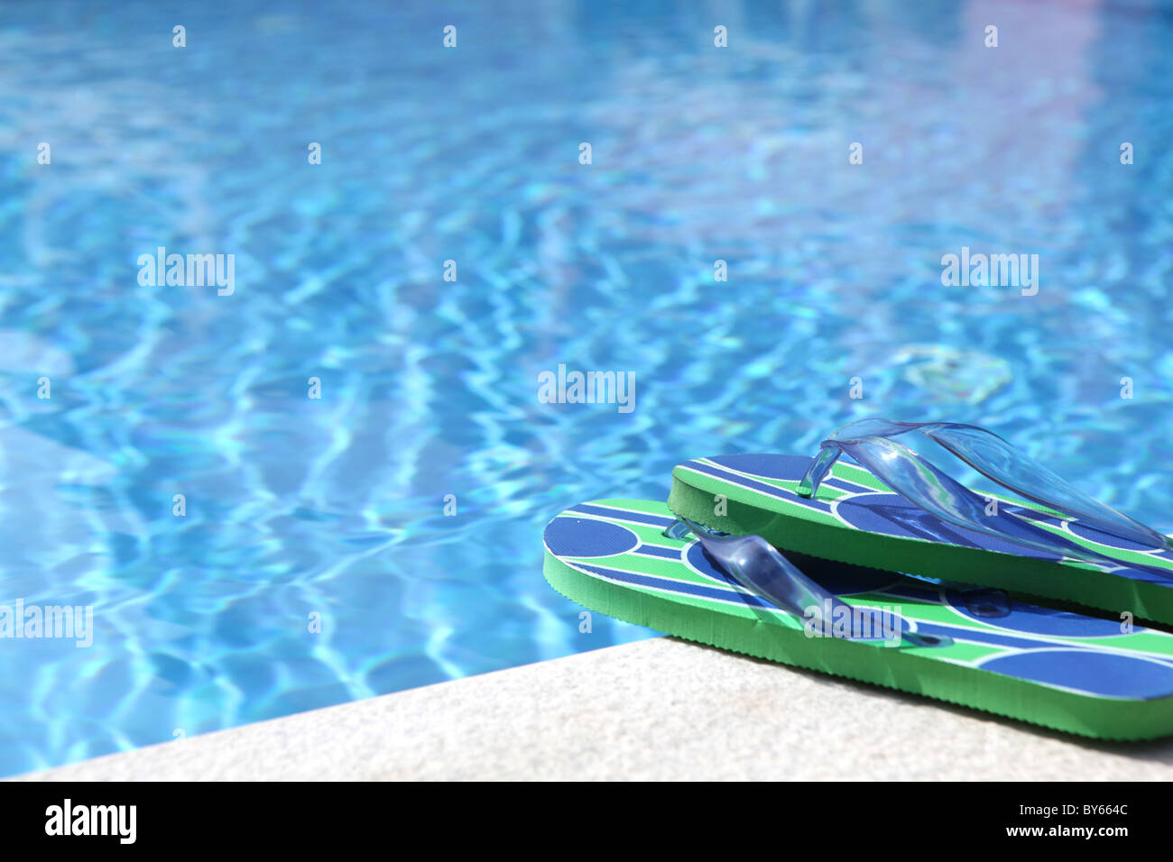 Pair of flip flops placed beside a swimming pool in summer Stock Photo ...