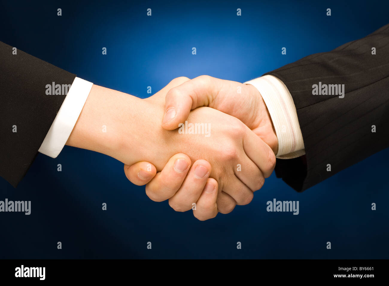 Business handshake - making a deal over a blue background Stock Photo ...