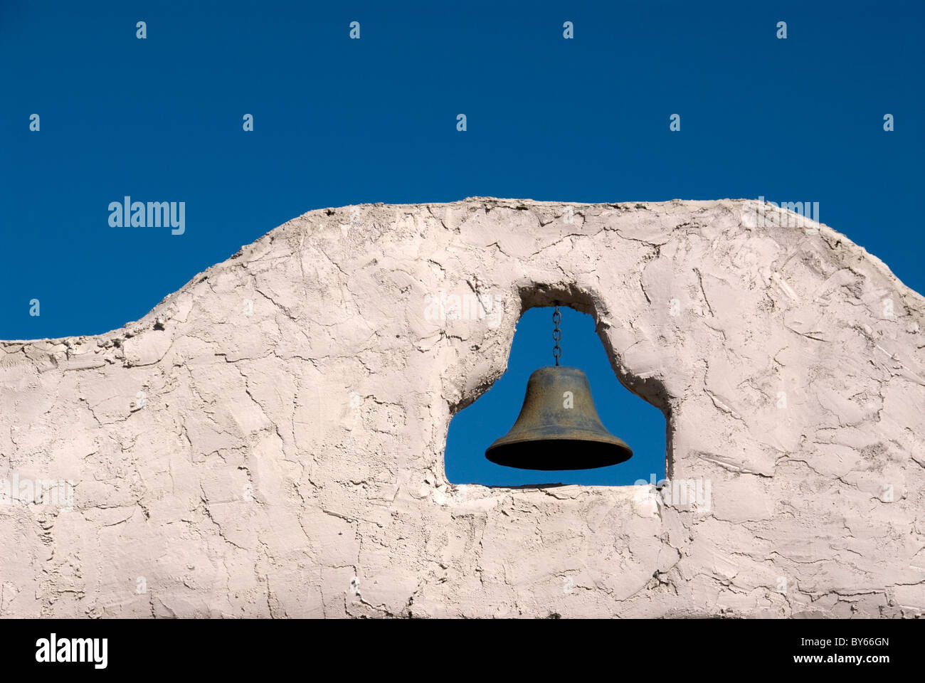 Bell hanging in the middle of adobe style building Stock Photo - Alamy