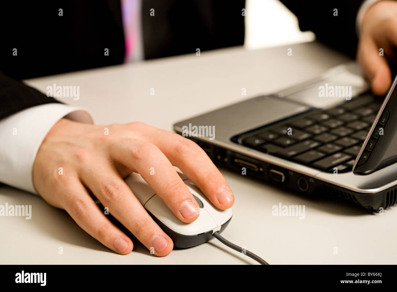 Human hands touching computer mouse and keys of opened laptop Stock ...