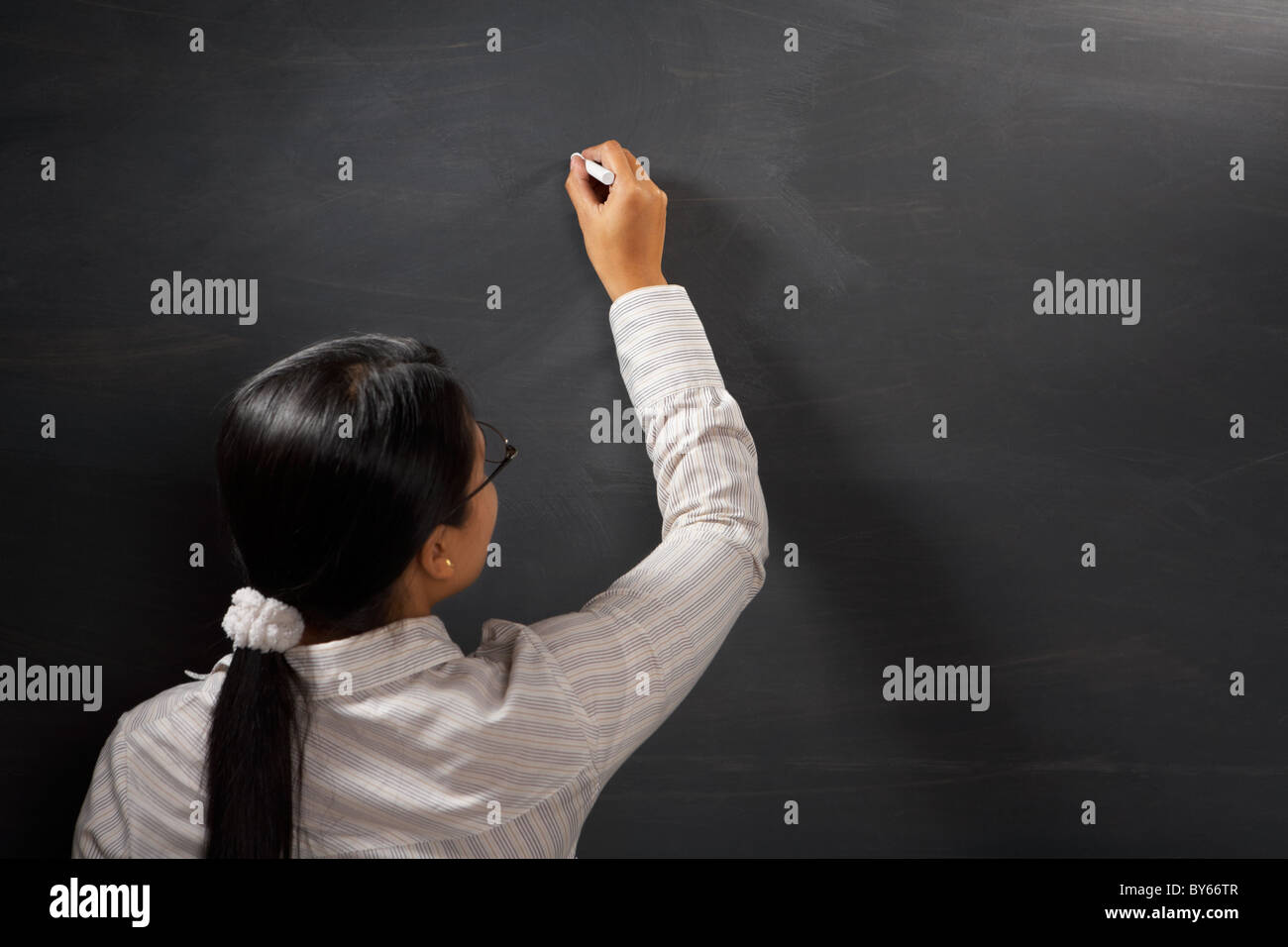 Female teacher holding chalk on blank blackboard Stock Photo - Alamy