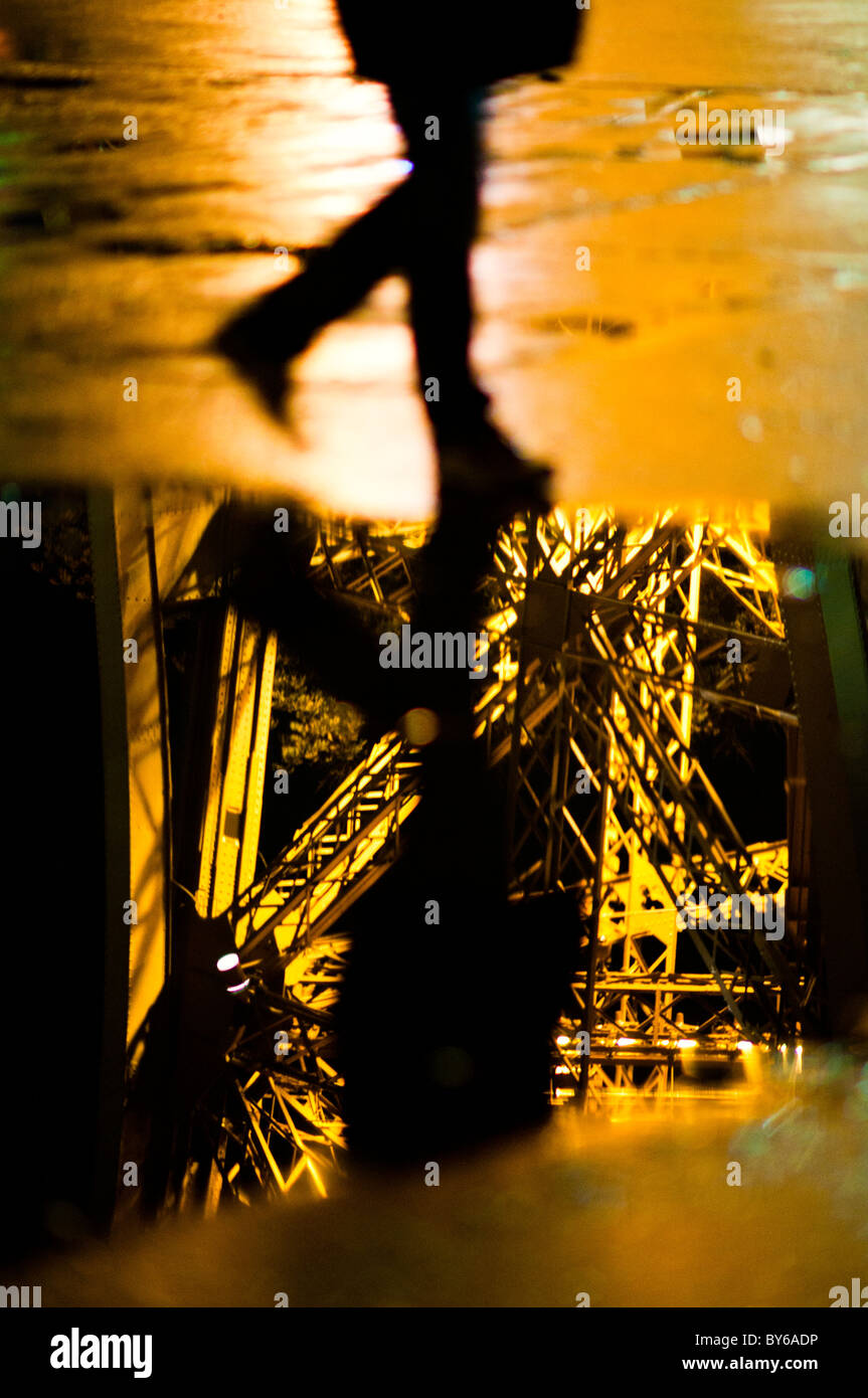 PARIS, France — A passerby walks past a puddle reflecting some of the ...