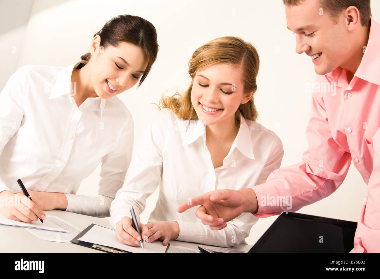 Image of young man pointing at paper in which pretty female going to ...