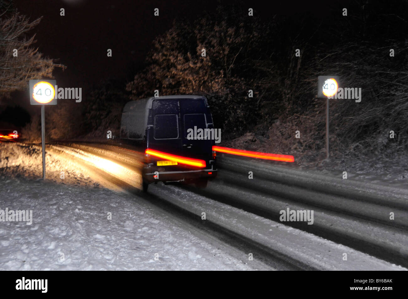 Van driving on snow covered gritted road at night vehicle passing 40 ...