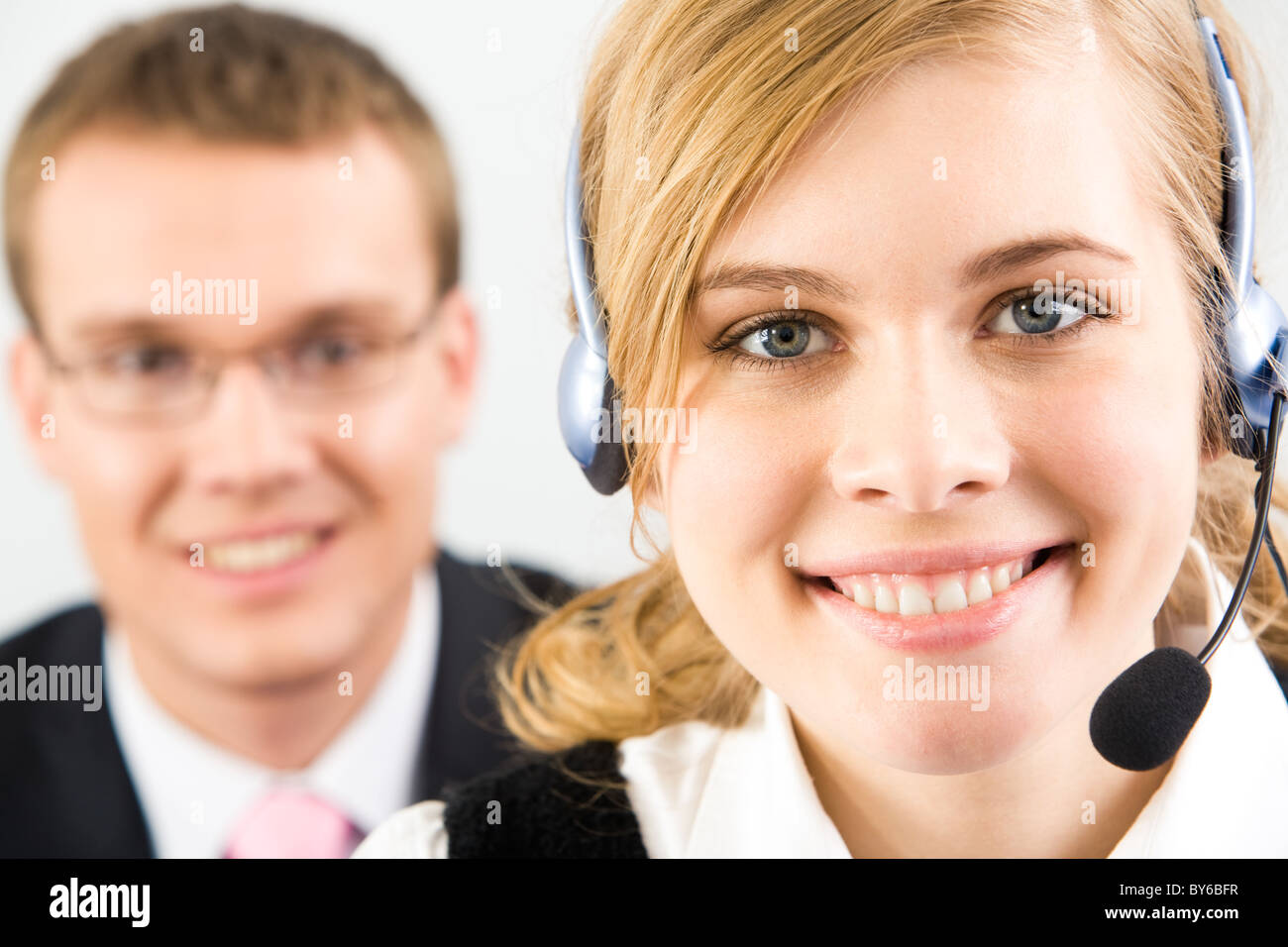 Face of pretty secretary wearing headset on background of confident ...