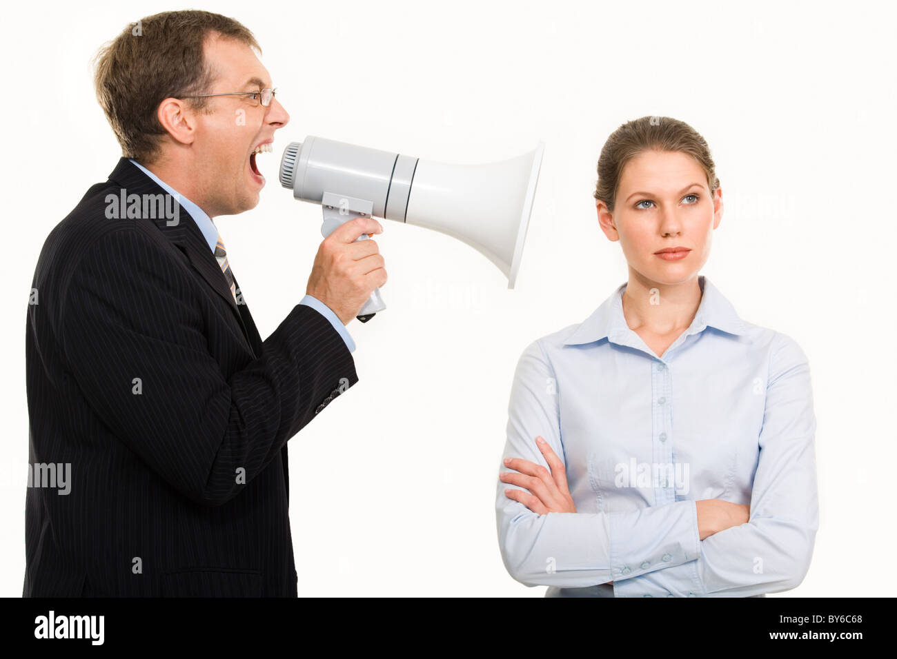 Portrait of angry boss shouting at his secretary through megaphone who ...