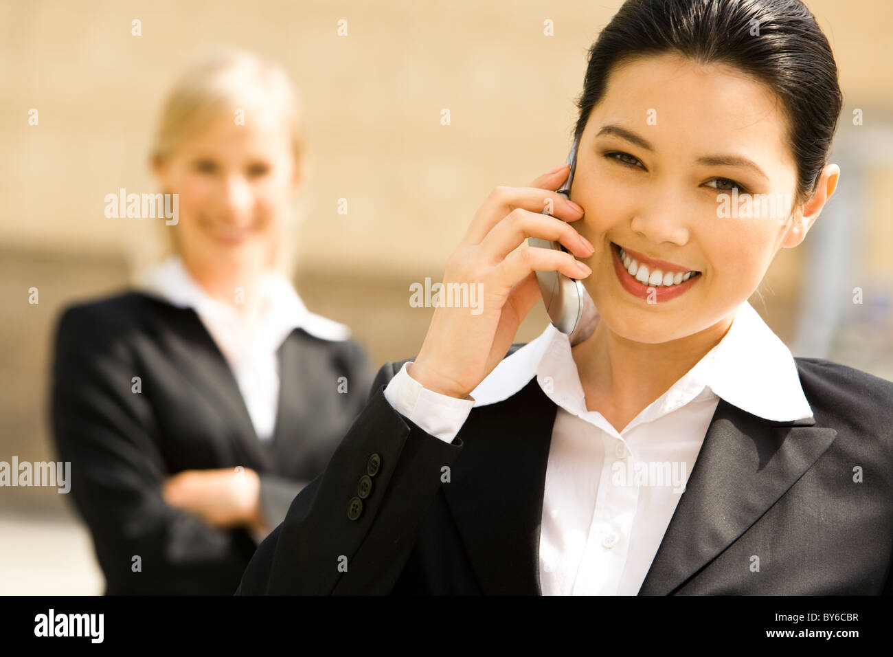 Portrait of successful secretary calling by phone on the background of ...