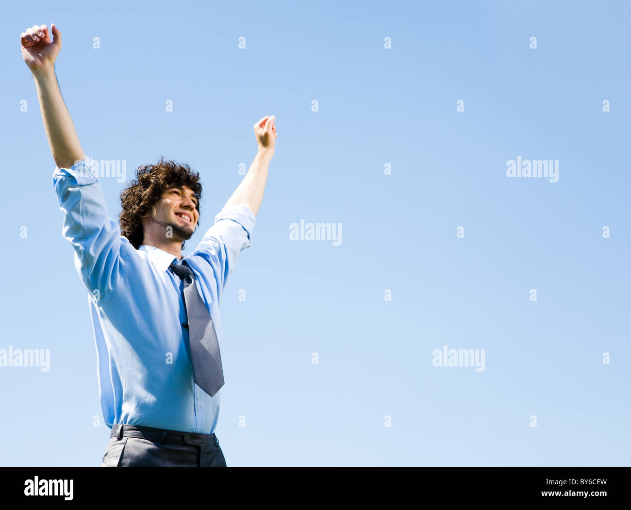 Portrait of happy businessman lifting up hands on the background the ...