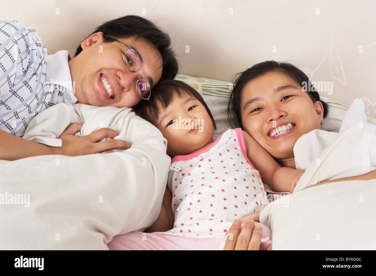 Chinese family having fun on bed showing love and togetherness Stock ...