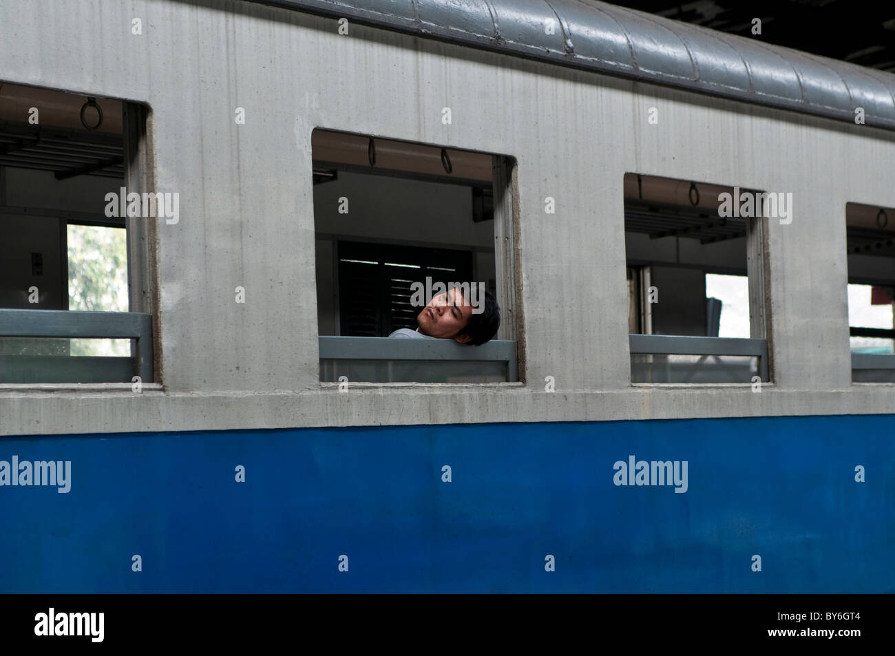 Man leaning out of train window at Bangkok railway station, Thailand ...